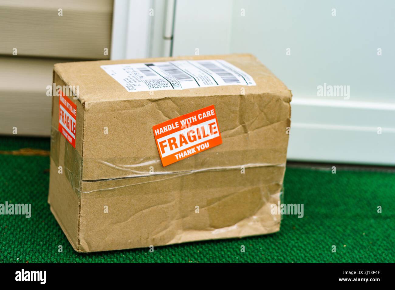 A package outside a residential door with a fragile, handle with care ...