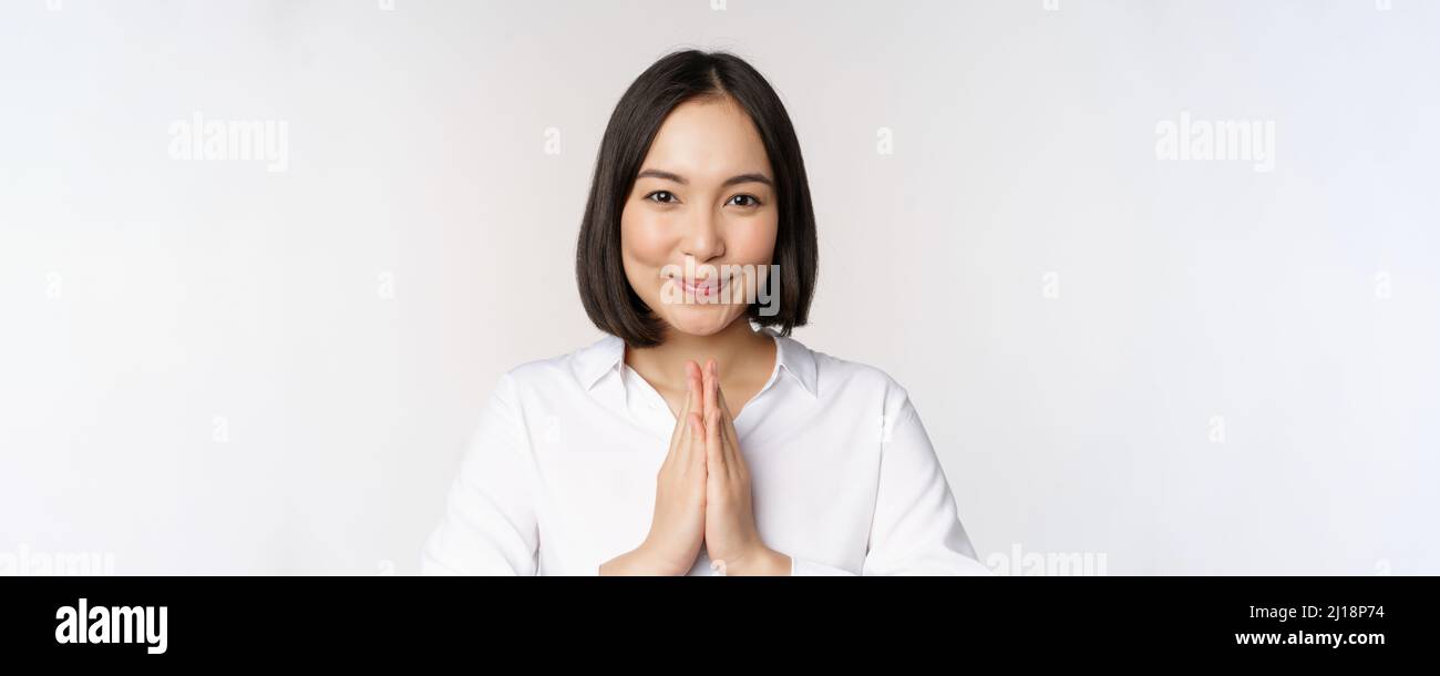 Close up portrait of young japanese woman showing namaste, thank you ...