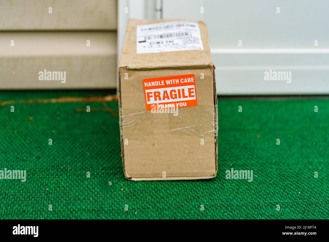 A package outside a residential door with a fragile, handle with care ...