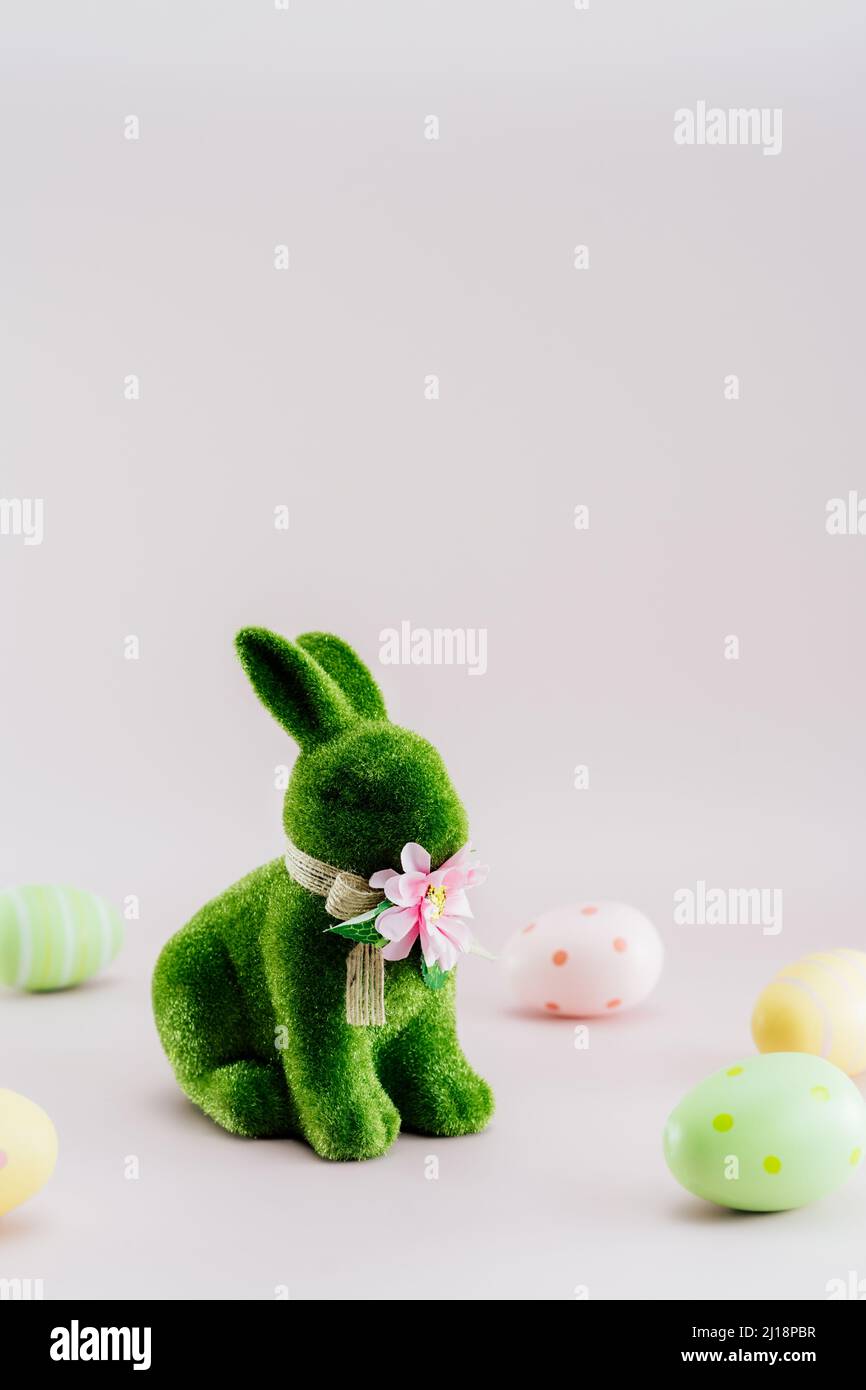 Green bunny rabbit figurine and colored easter eggs in different ...