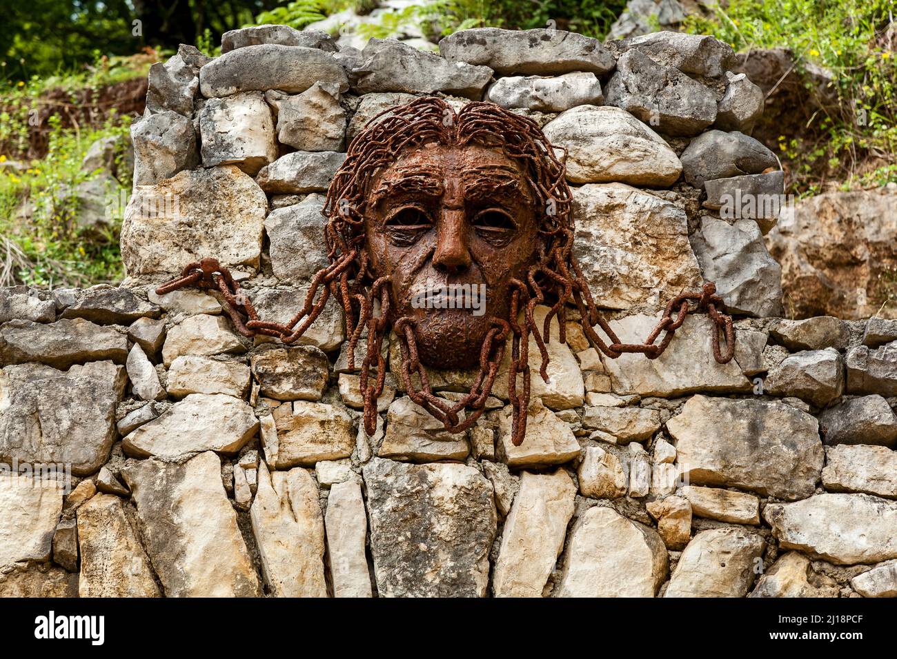 Rusty iron male face mask with chains on a stone wall Stock Photo - Alamy