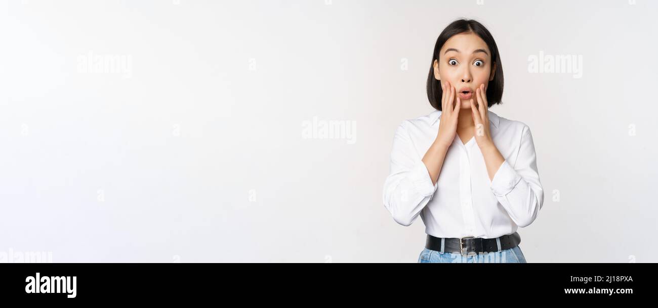 Image of asian female model looking surprised, staring amazed, reacting ...