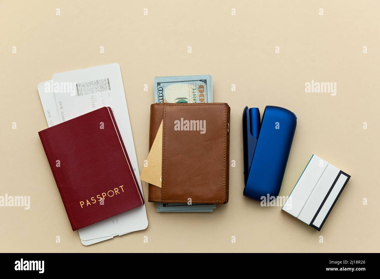 Electronic blue IQOS cigarette, passport with air tickets and purse ...