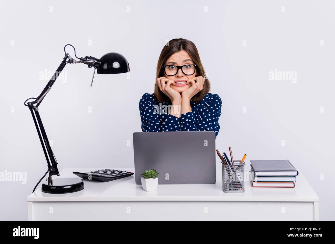 Photo of nervous worried office employee lady sit desk bite fingers ...
