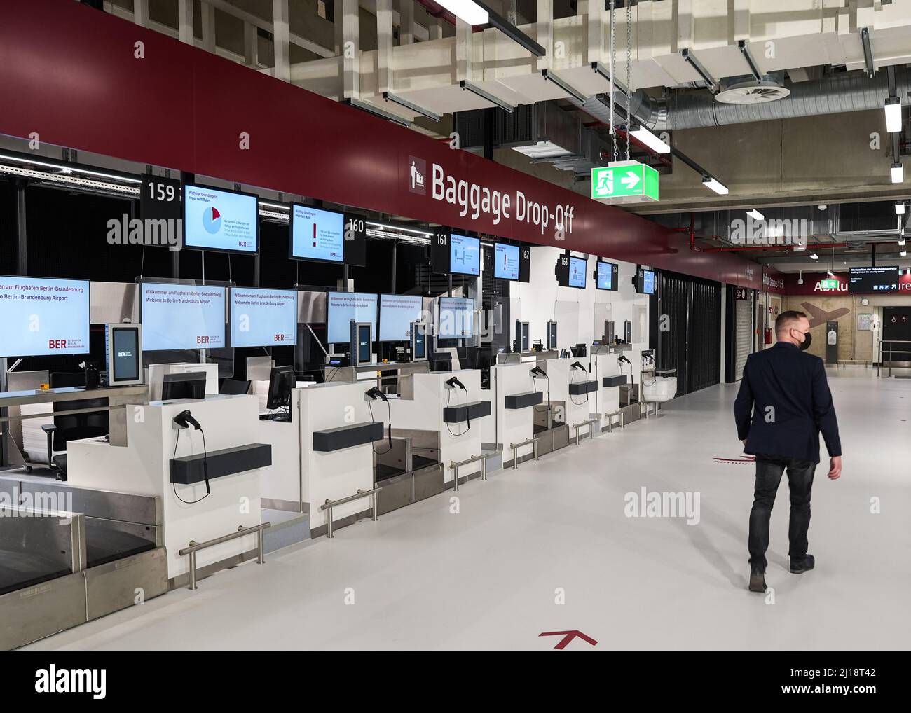 Schoenefeld, Germany. 23rd Mar, 2022. A staff member walks past check ...