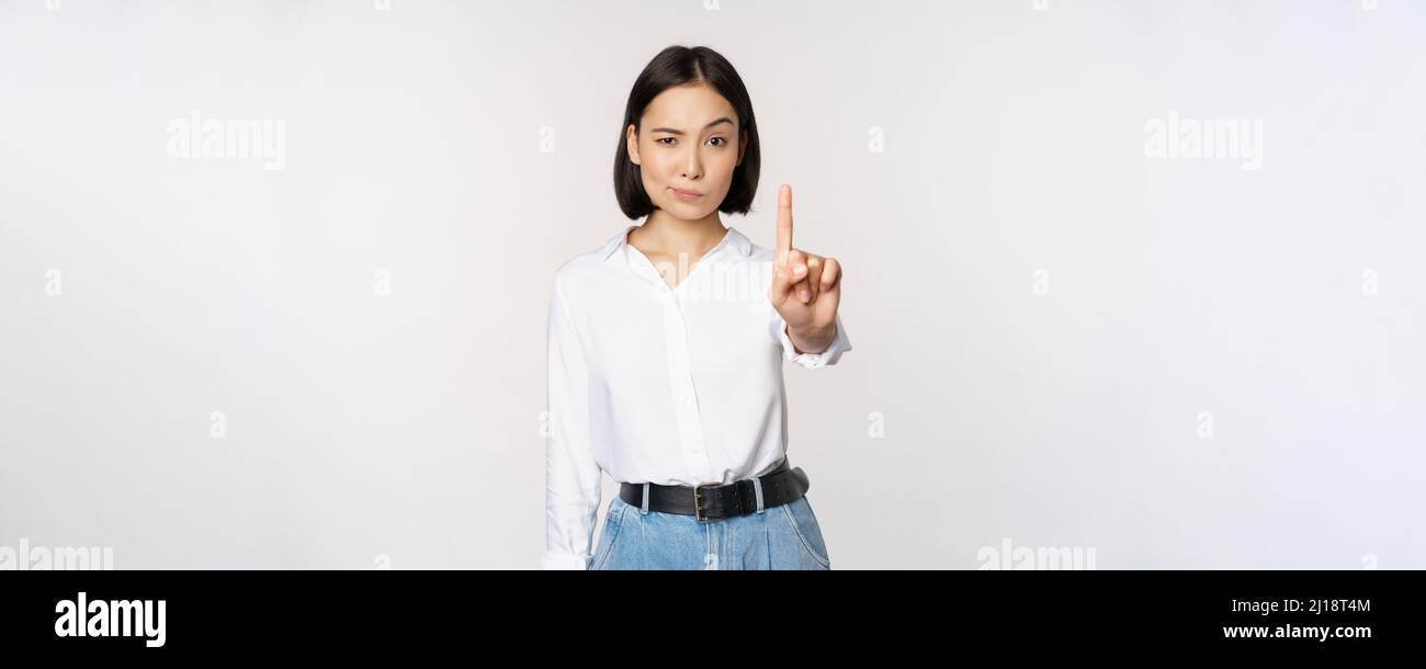 No. Young serious and confident asian woman showing stop, one finger ...