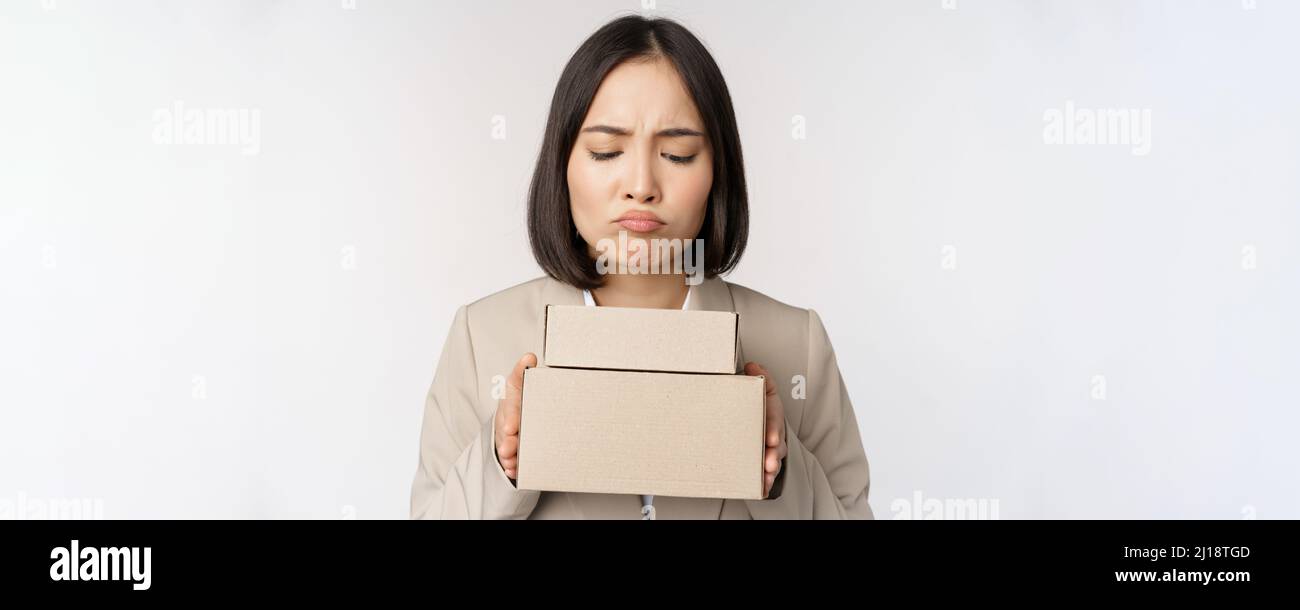 Portrait of asian saleswoman, female entrepreneur holding boxes and ...