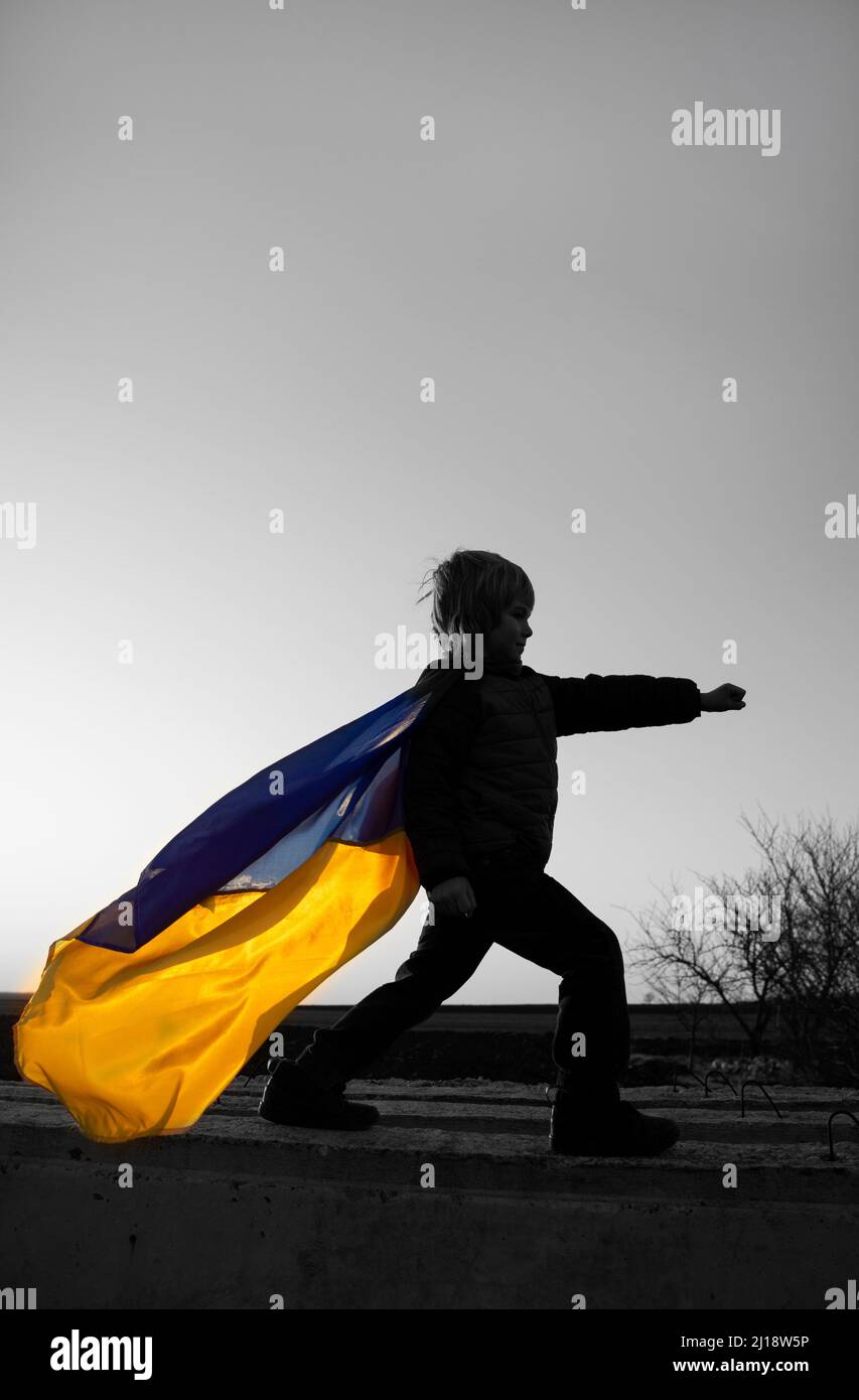 black and white portrait of boy superhero with a waving Ukrainian flag ...