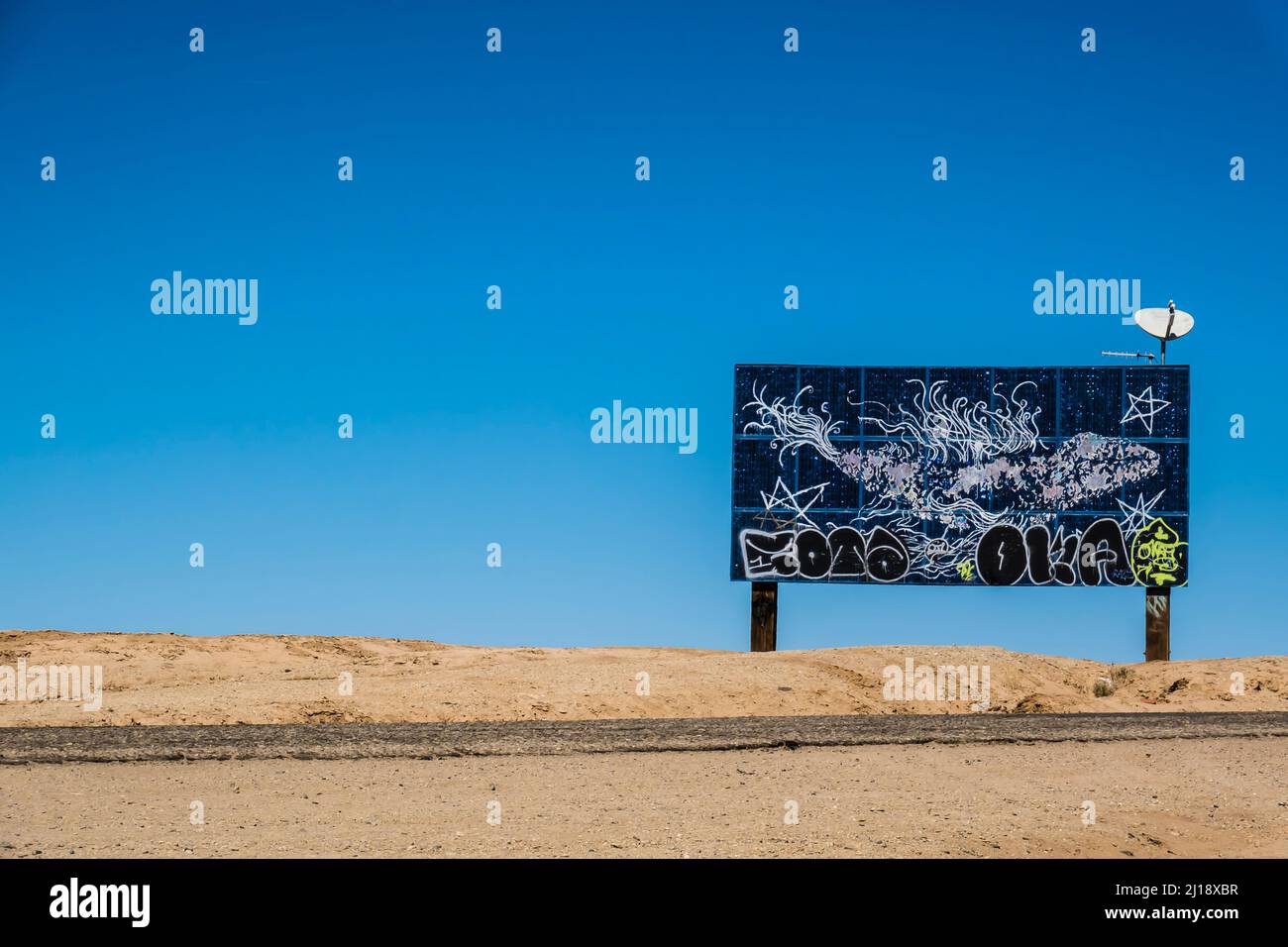 A billboard covered with Graffiti across the road from Salvation ...