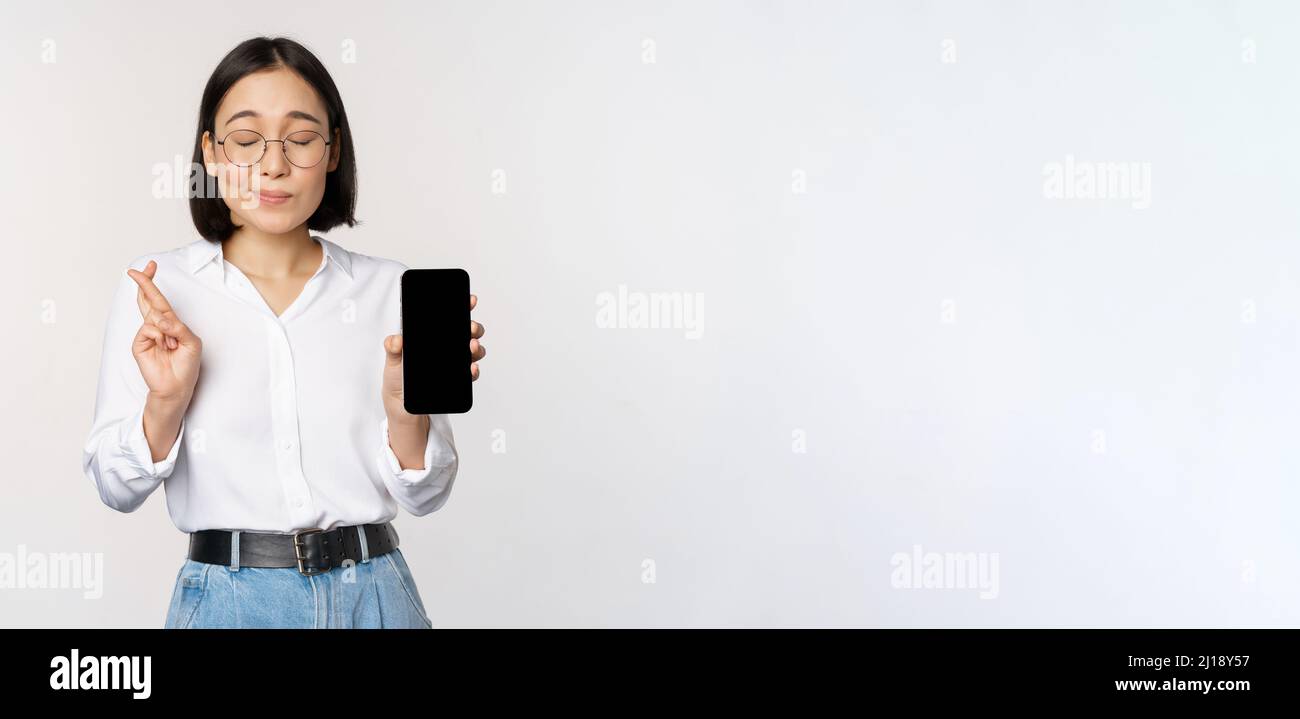 Hopeful young asian woman, showing mobile phone screen, app interface ...