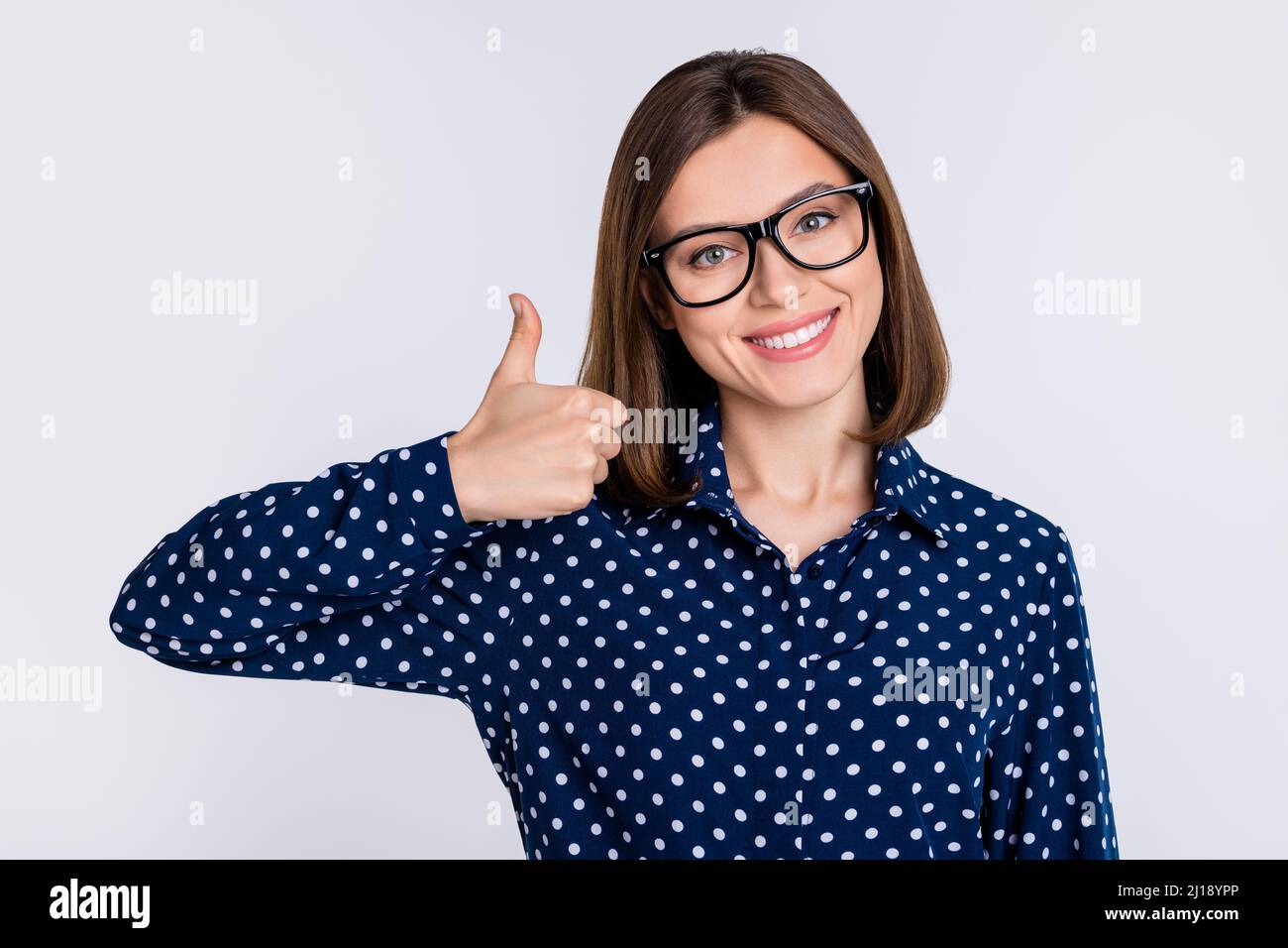 Portrait of attractive cheerful brown-haired girl showing thumbup ad ...