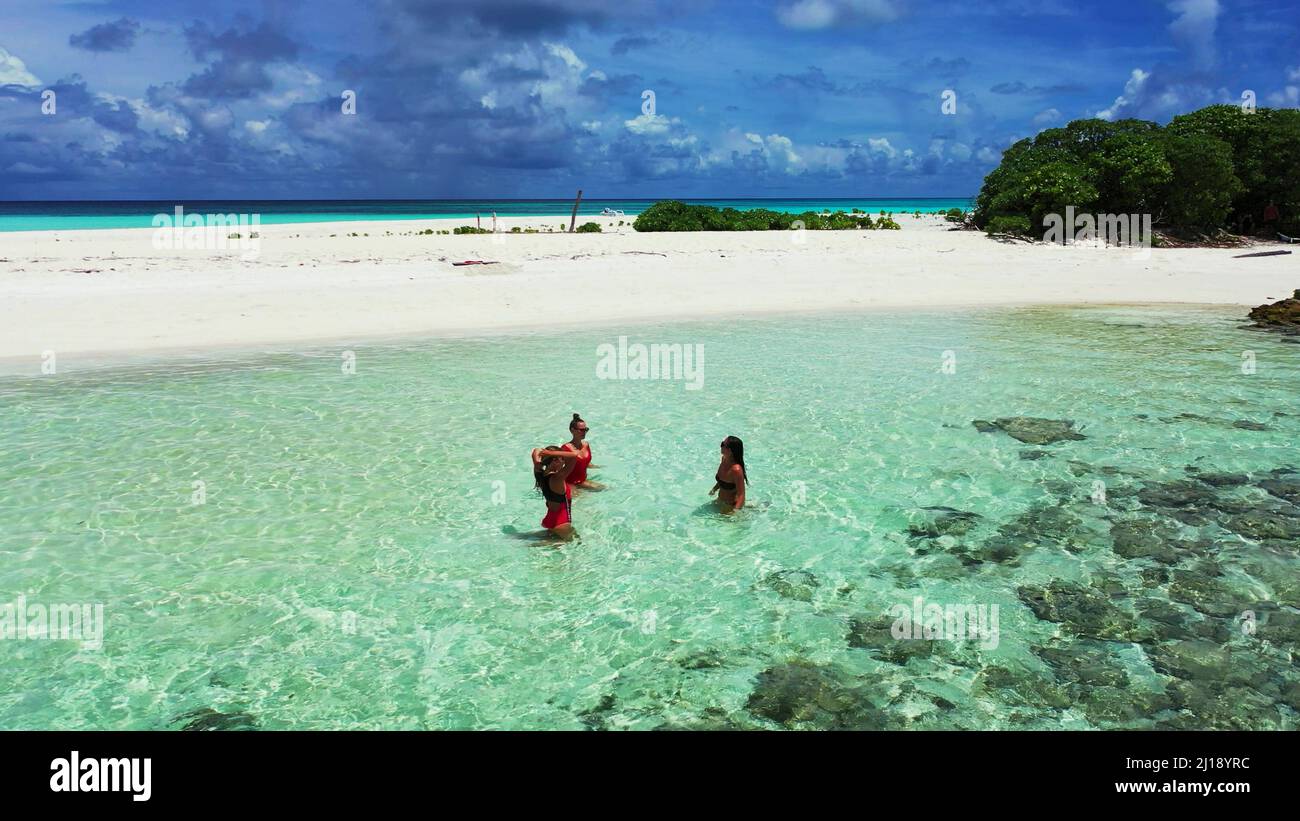 A group of women in azure waters of Fulhadhoo Island, The Maldives ...