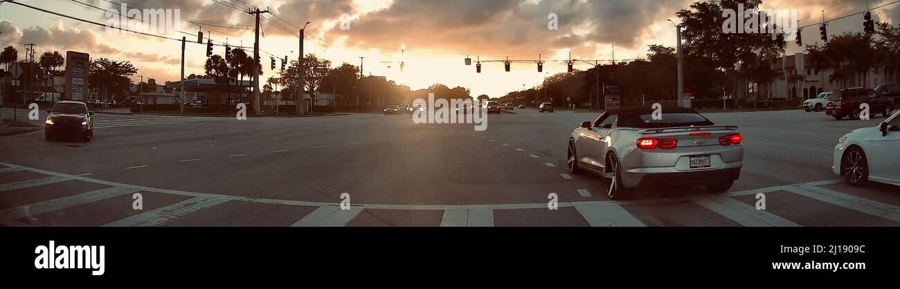Panoramic view from car on city intersection at sunset day in Florida ...