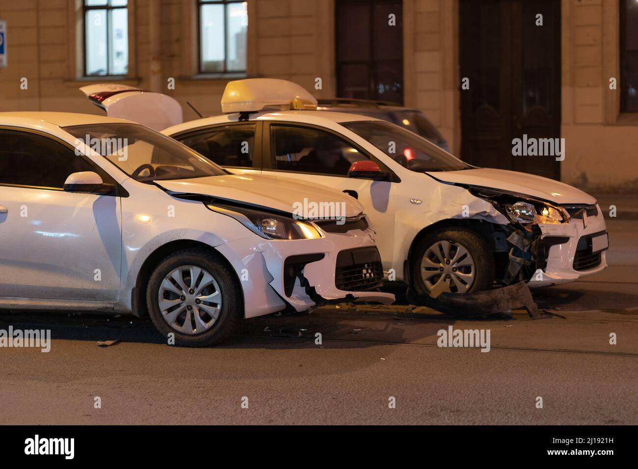 Damaged white cars on the road after accident with damaged bumpers ...