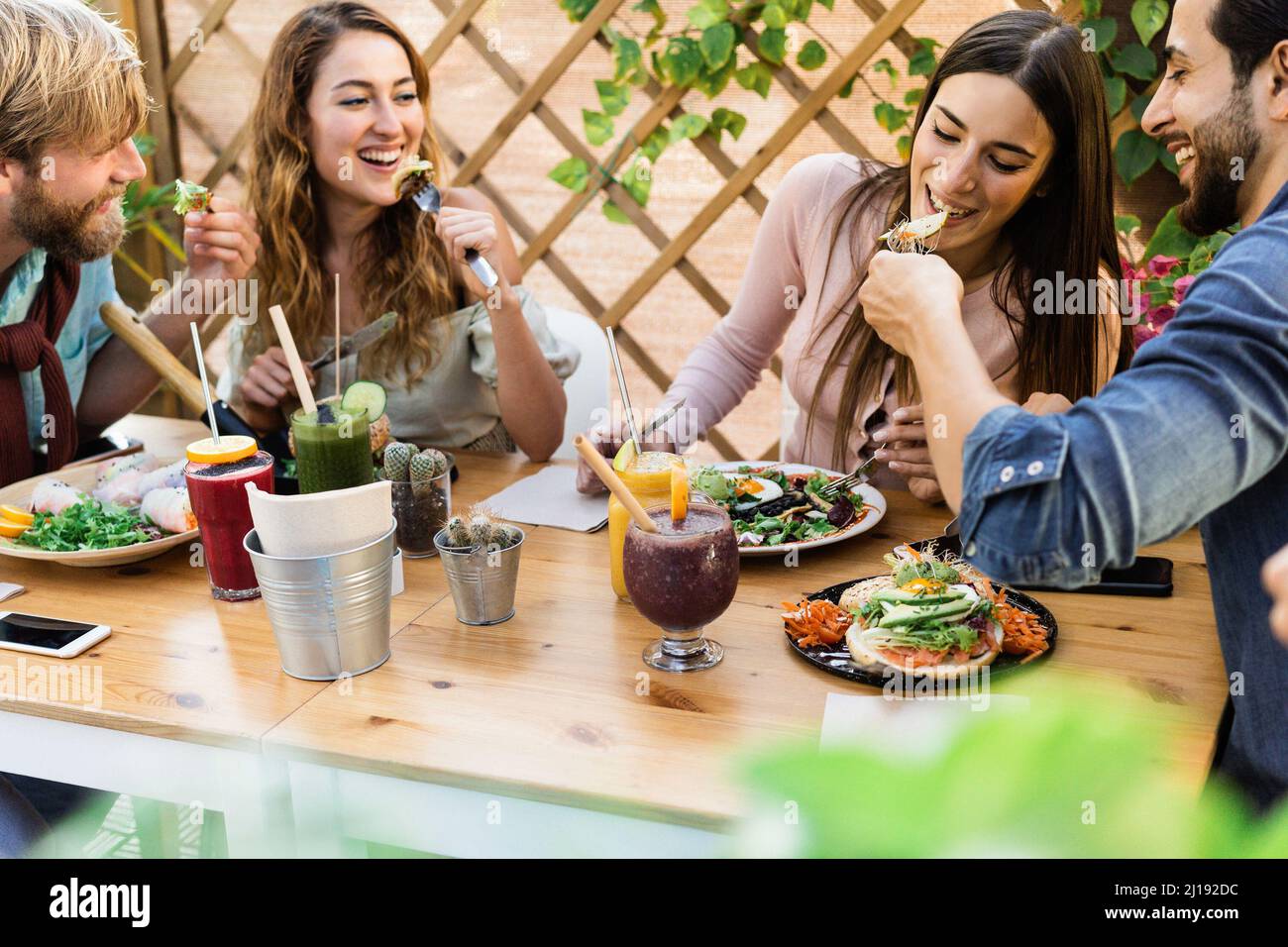 Young friends having fun eating brunch at healthy food restaurant ...