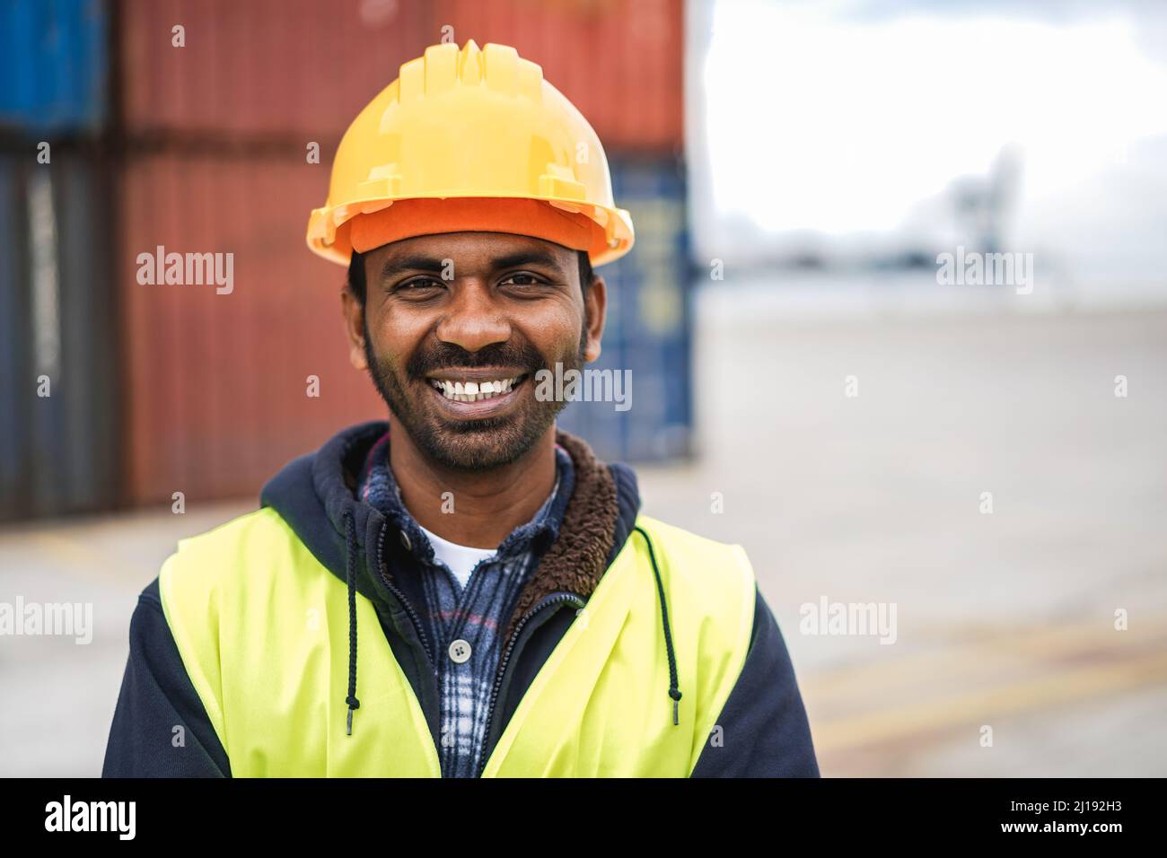 Happy Indian man smiling on camera working with industrial port on ...