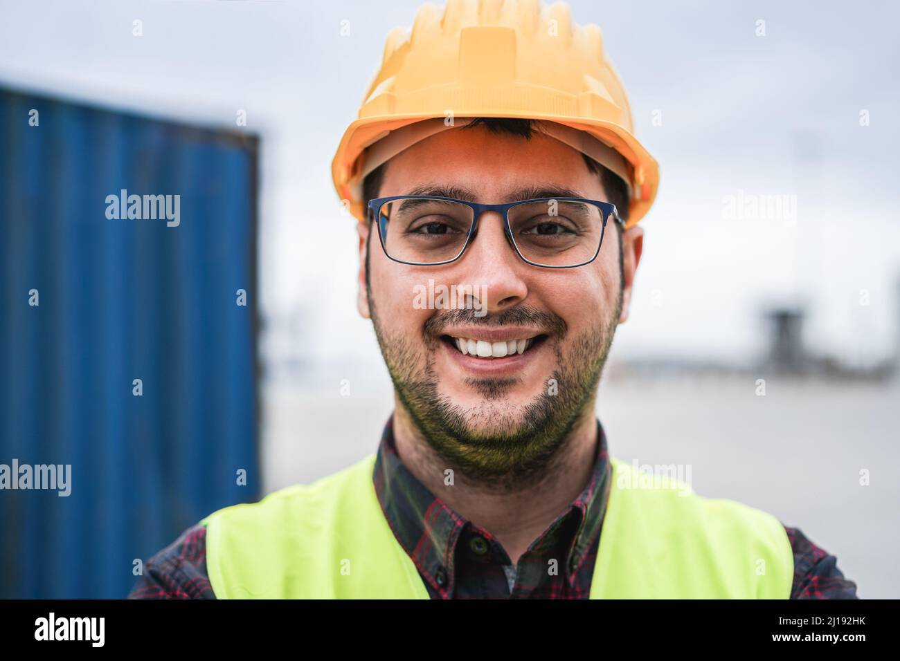 Happy young man smiling on camera working at freight terminal port on ...