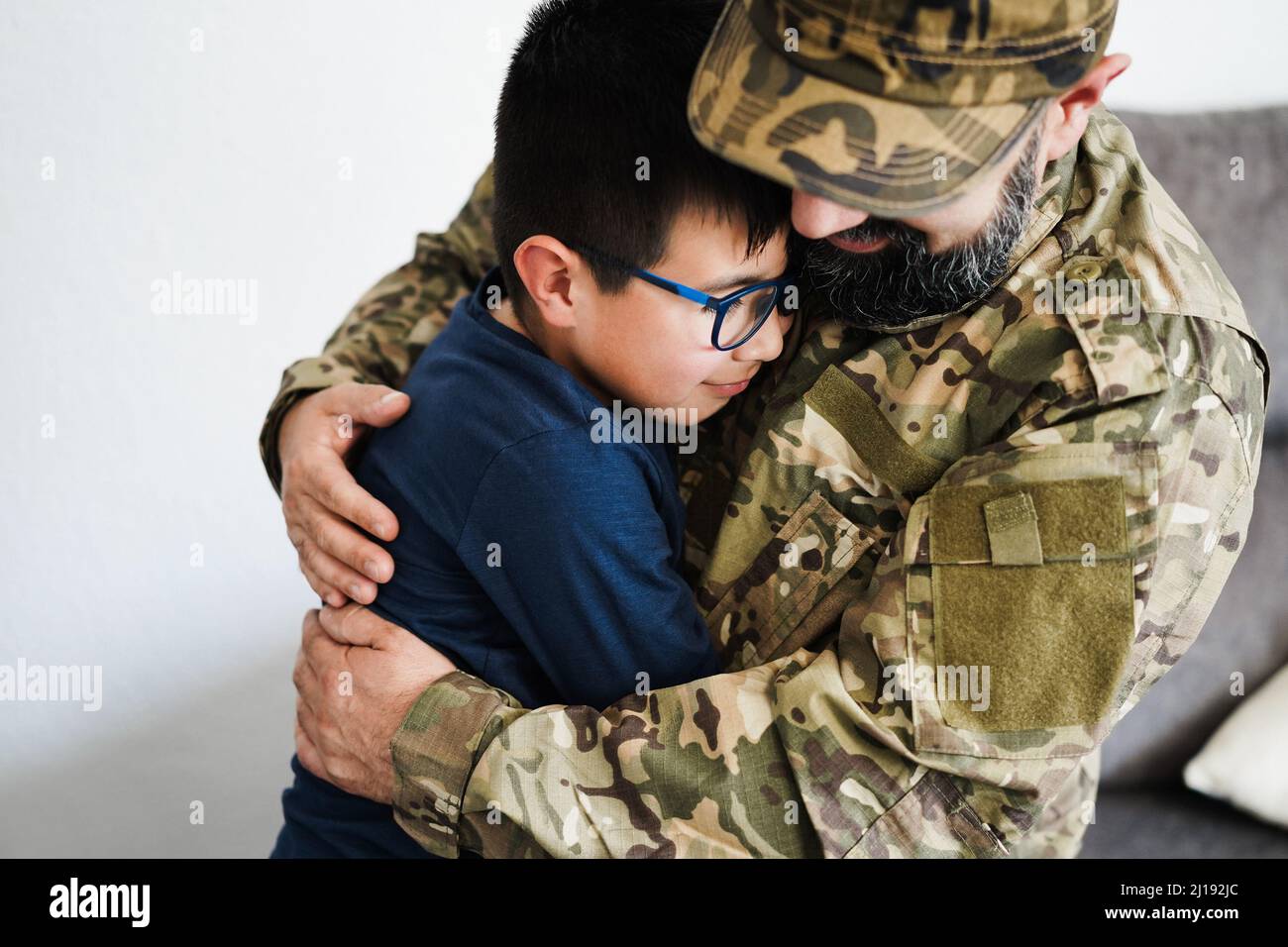 Soldier greeting and hugging his son at home - Focus on kid face Stock ...