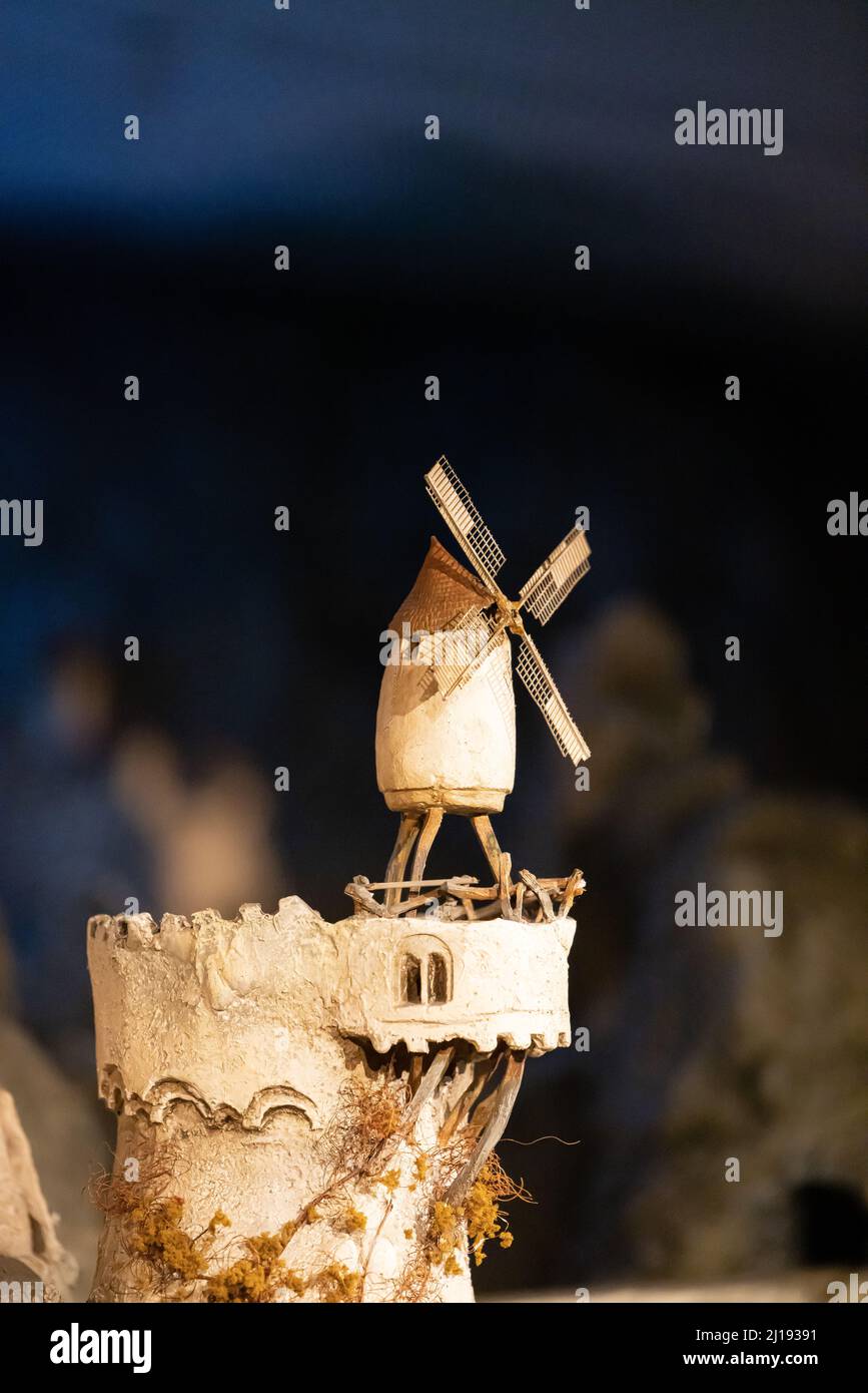 A vertical closeup shot of a miniature windmill on top of a tower on a ...