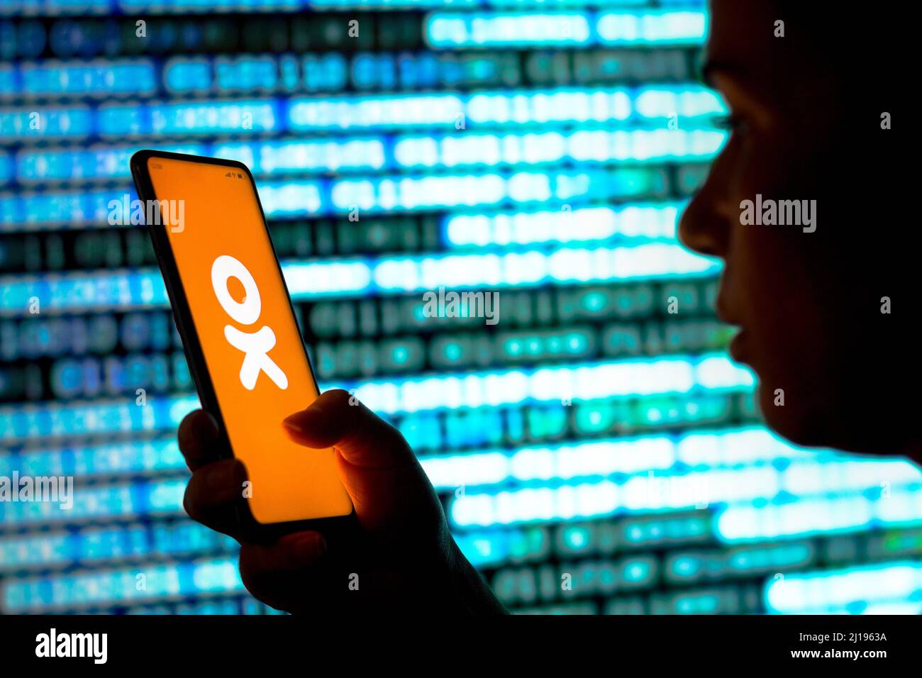 In this photo illustration, a woman's silhouette holds a smartphone ...