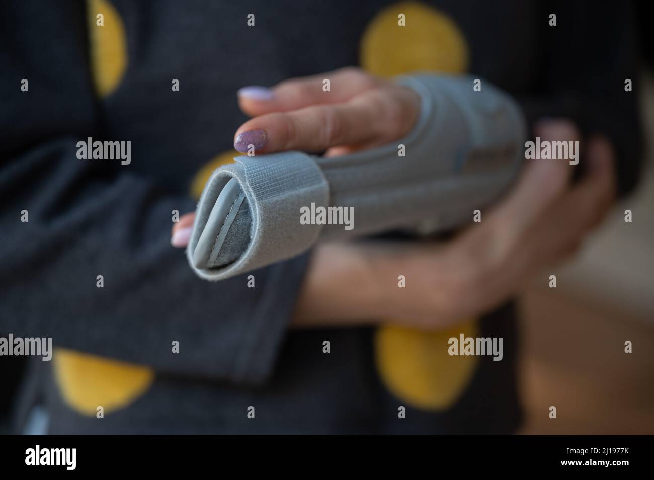 Closeup view of a woman protecting her broken finger secured in an ...