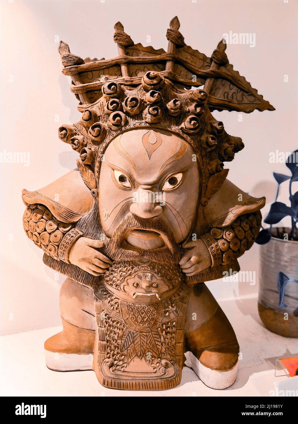 The close-up shot of a clay statue of a small Asian man which can be a ...