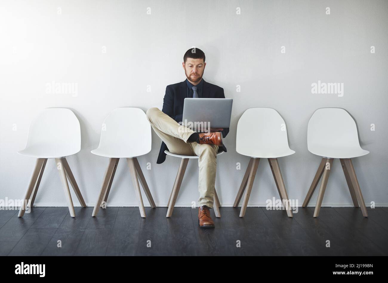 Keeping me busy waiting. Studio shot of a businessman waiting in line ...