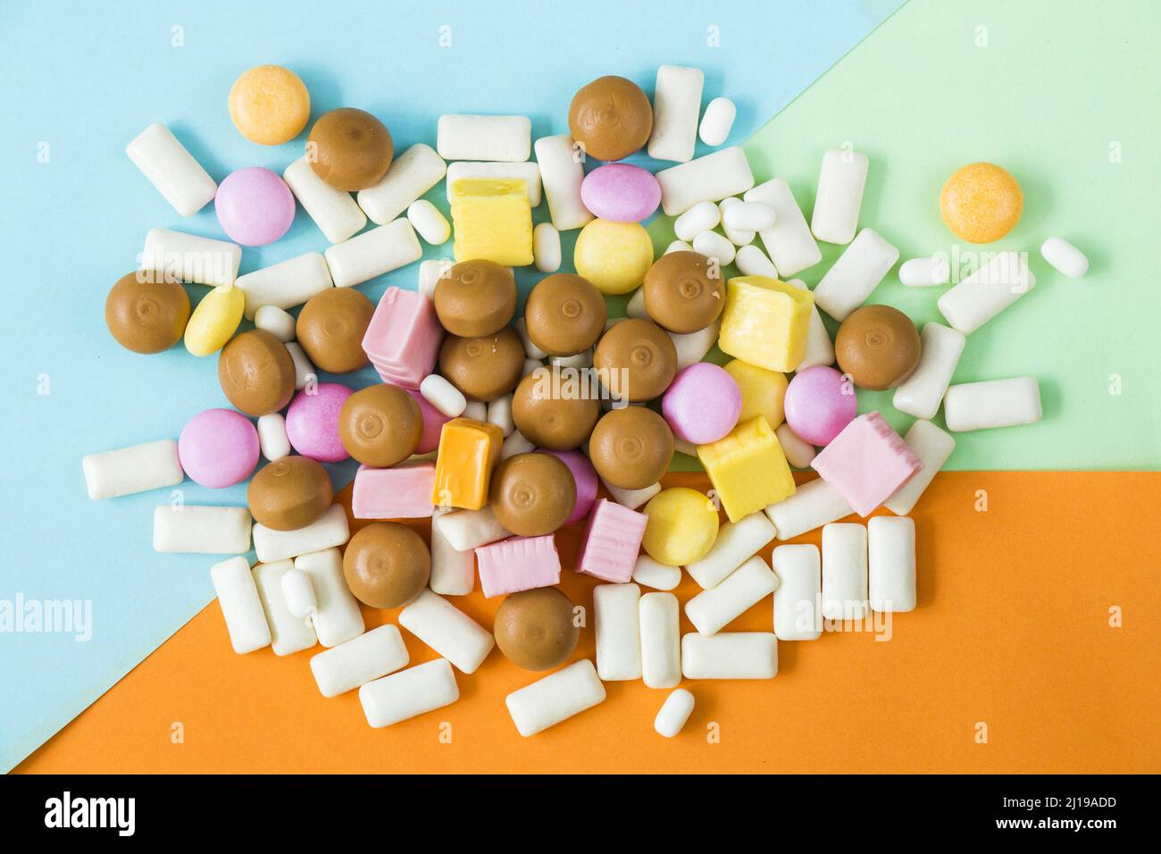 A top view of sweet colorful confectionery, candies on the color ...