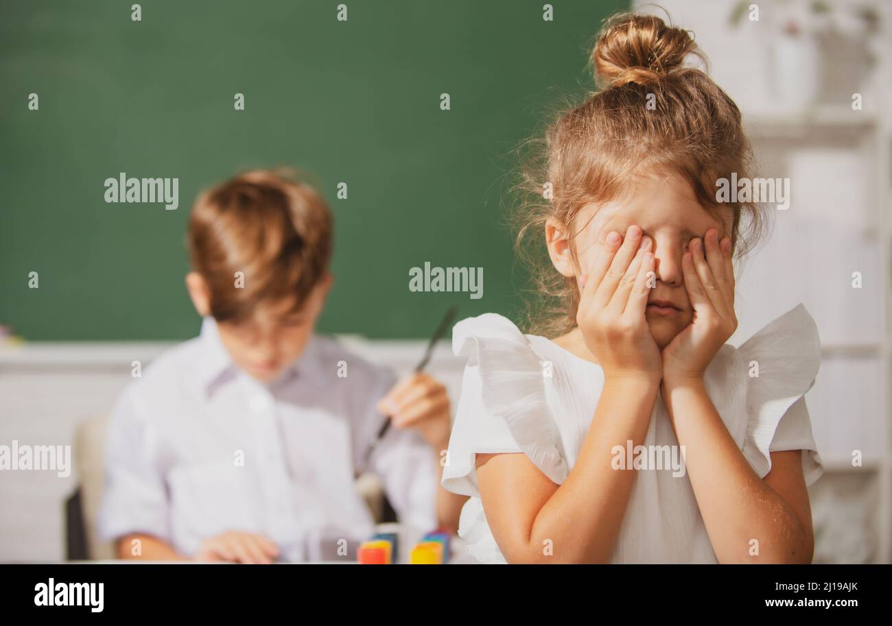 A smart school girl cry. Schoolgirl in uniform covering her face with ...