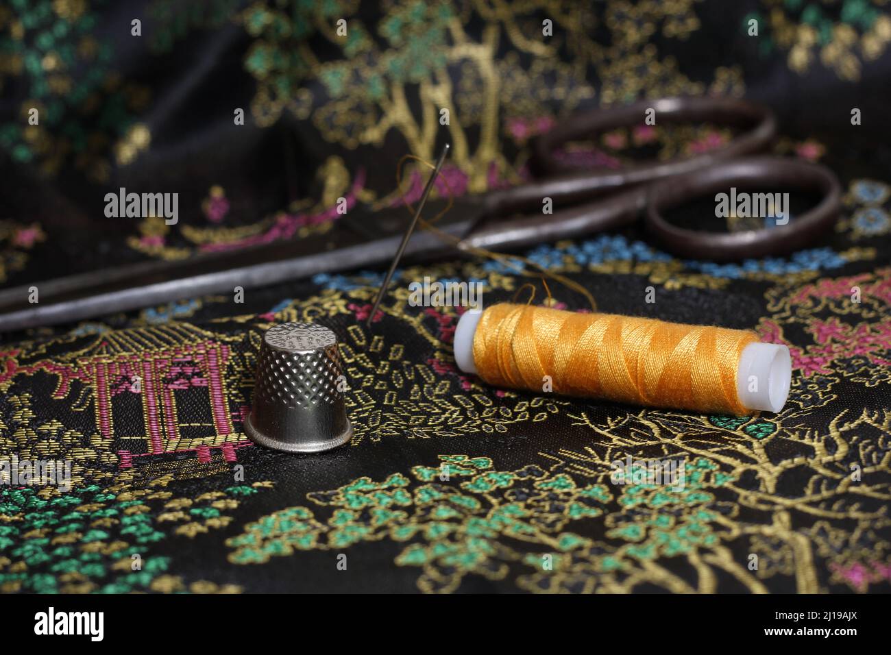 Yellow Thread and Thimble on Vintage Chinese Silk Stock Photo - Alamy