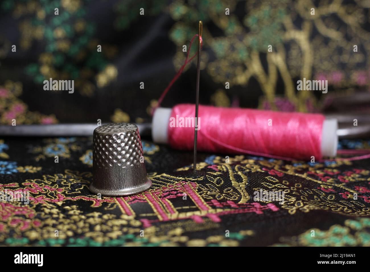 Pink Thread and Thimble on Vintage Chinese Silk Stock Photo - Alamy