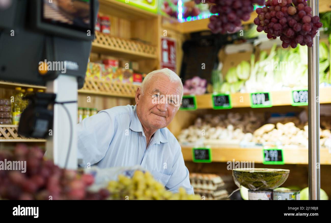 Old man seller standing at counter in greengrocer Stock Photo - Alamy