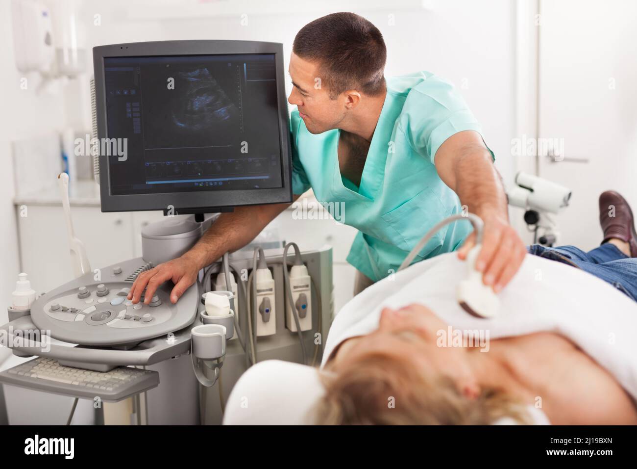 Doctor using ultrasound scan examining patient in hospital Stock Photo ...