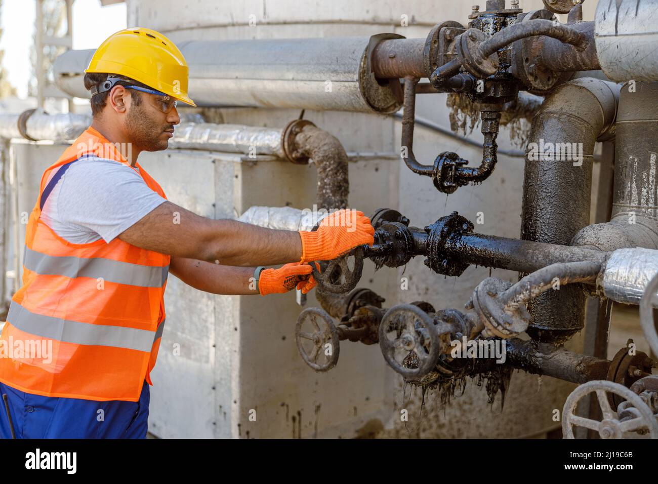 Young worker dressed in safety equipment inside factory Stock Photo - Alamy