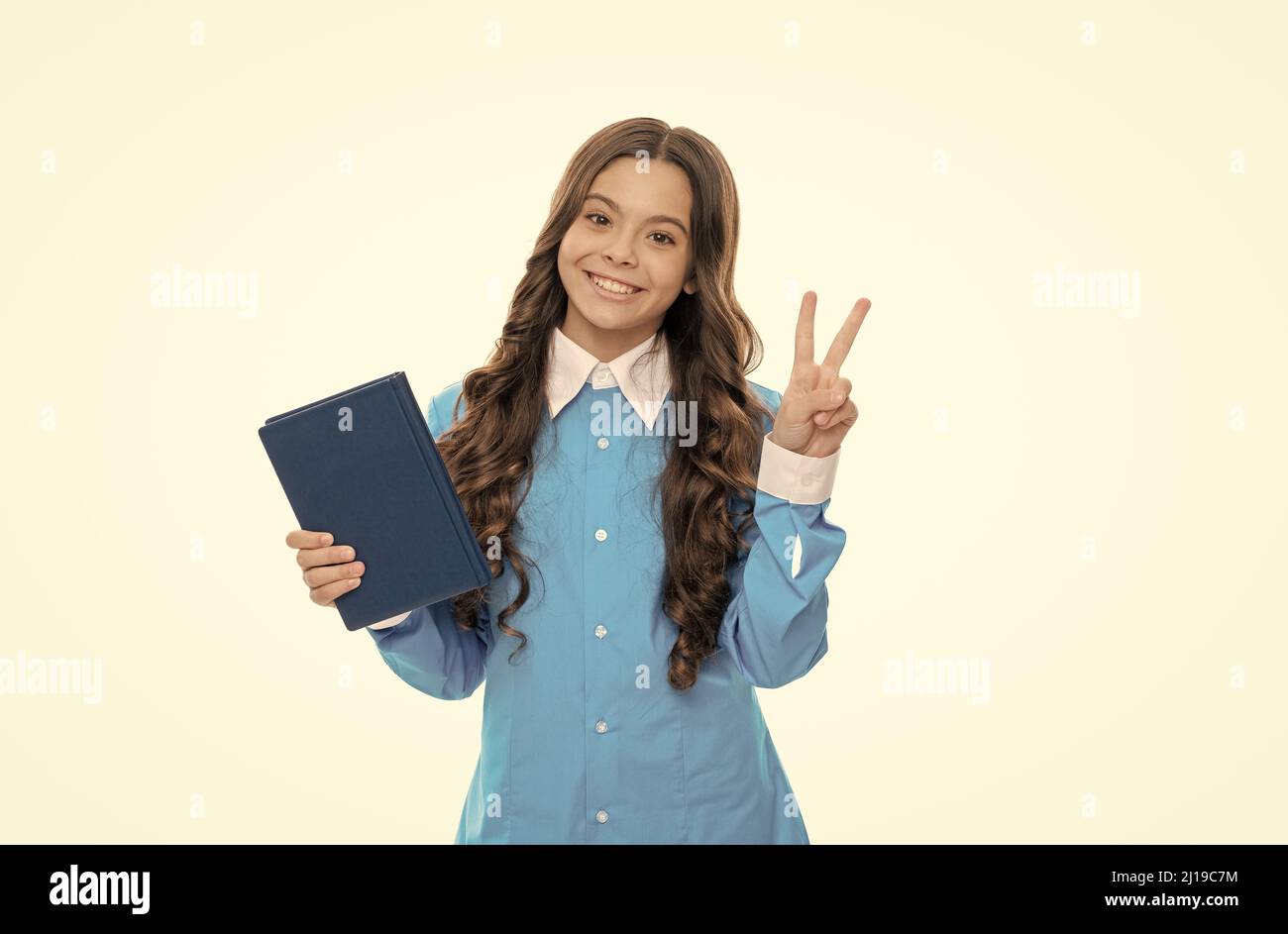 Happy child hold school book showing V hand signal isolated on white ...