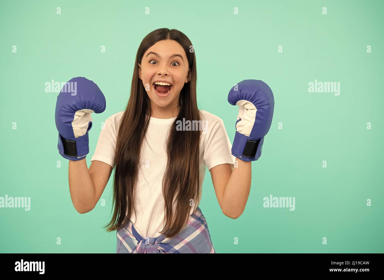 surprised teen girl boxer in boxing gloves during sport training, sport ...
