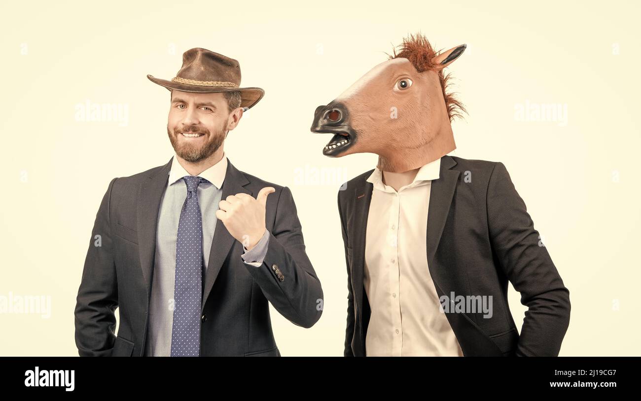 Happy cowboy man point finger at businessman wearing horse head ...