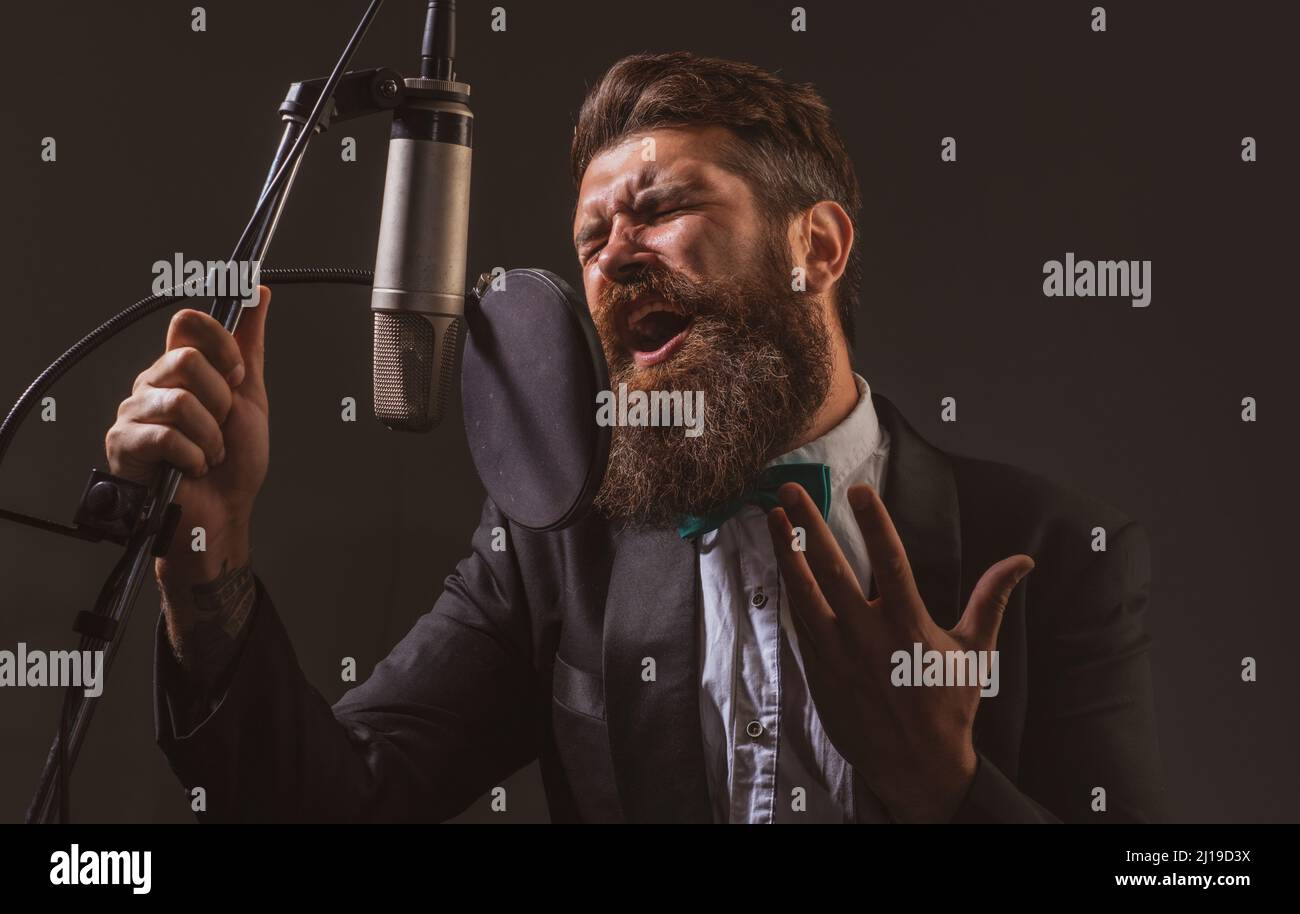 Singing man in a recording studio. Expressive bearded man with ...