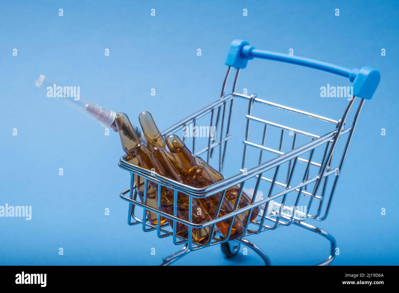 Basket with a syringe and an ampoule on a blue background Stock Photo ...