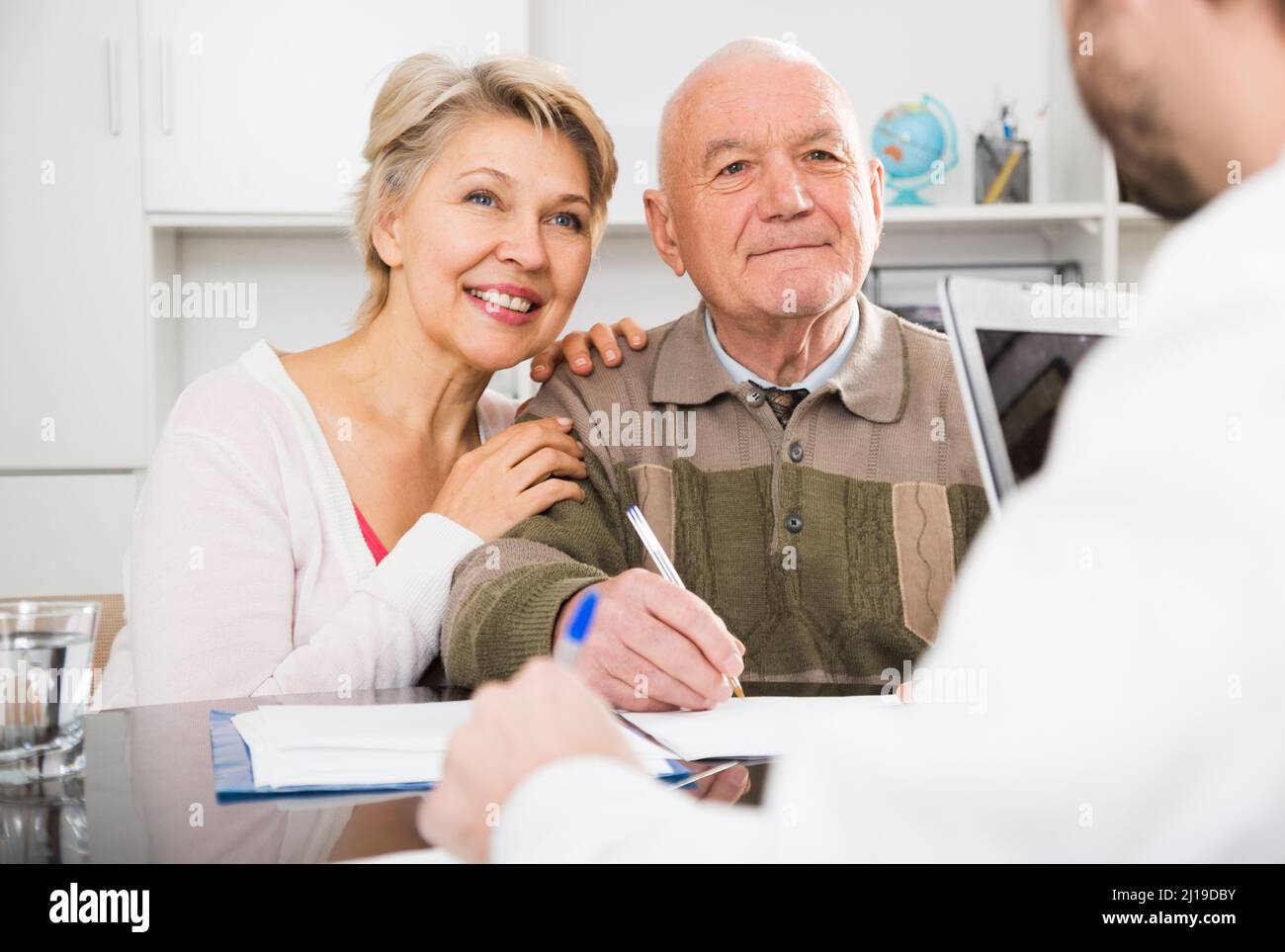 couple signing papers in bank Stock Photo - Alamy