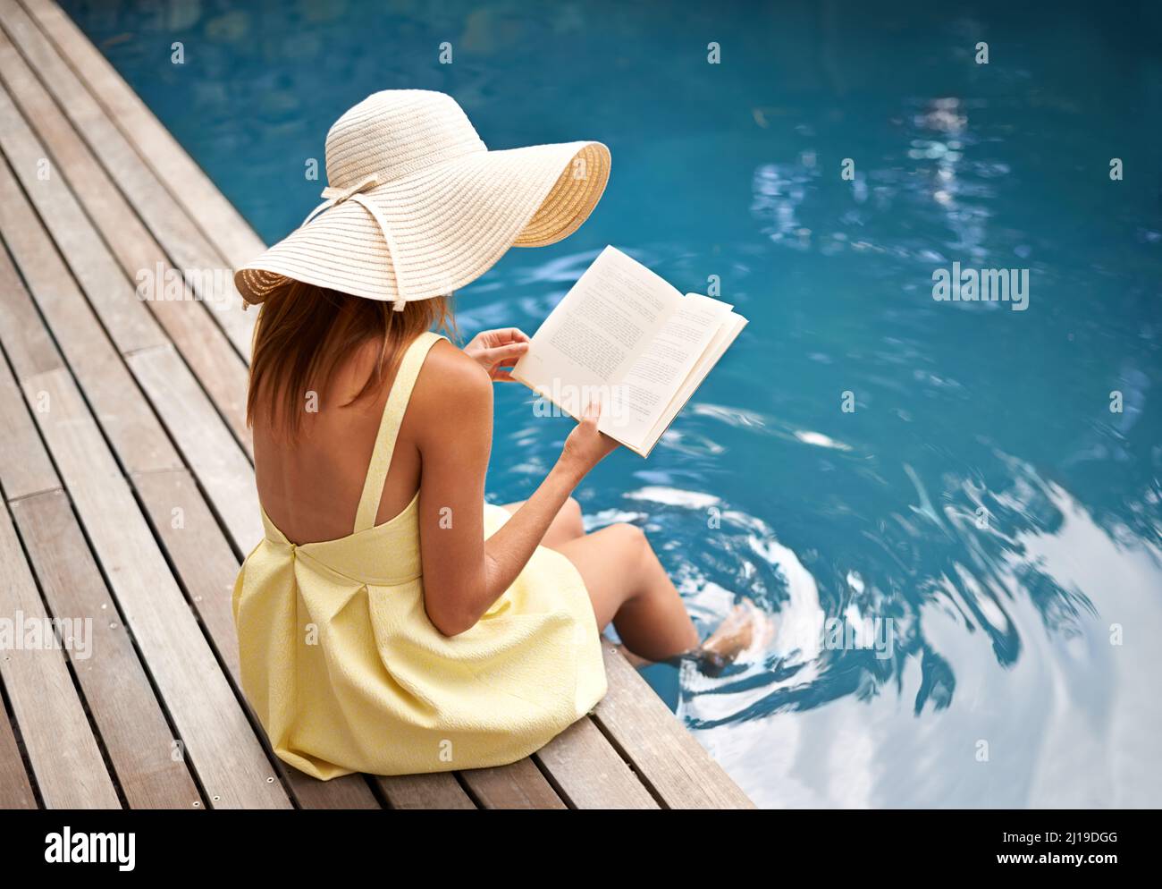 Woman reading book by pool hi-res stock photography and images - Alamy