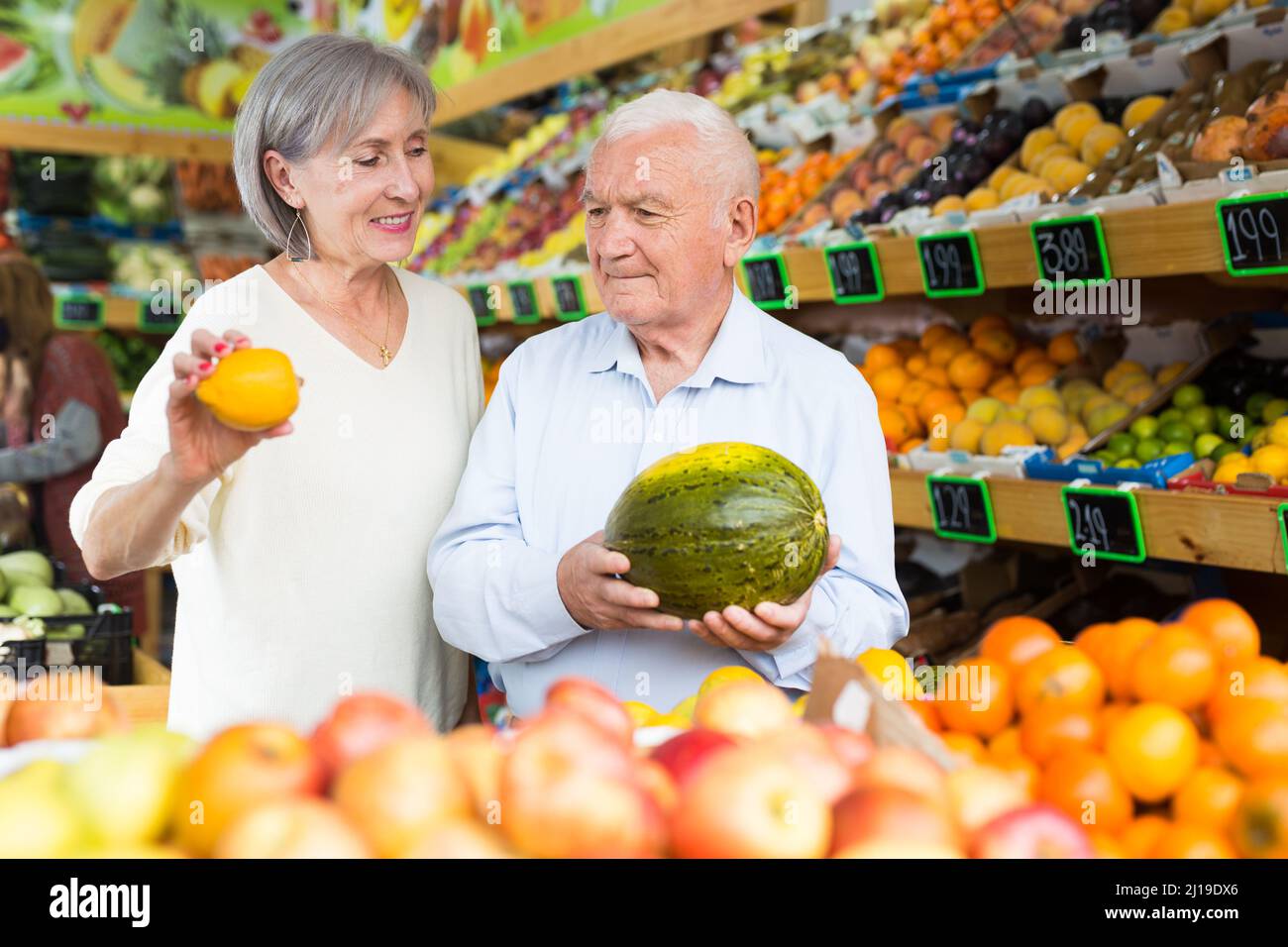 Elderly man and woman choosing fruits in supermarket Stock Photo - Alamy
