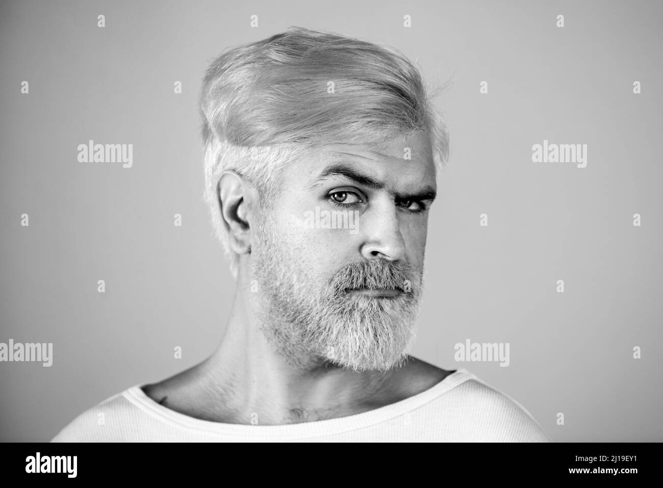 Portrait Of Blonde Serious Man Has Beard And Mustache Looks Seriously