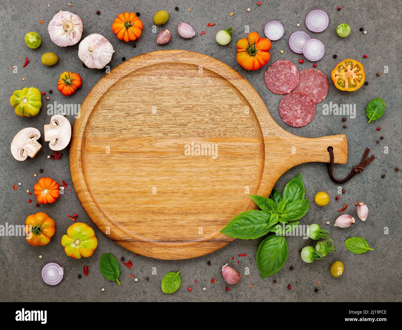 The ingredients for homemade pizza set up on dark stone background ...