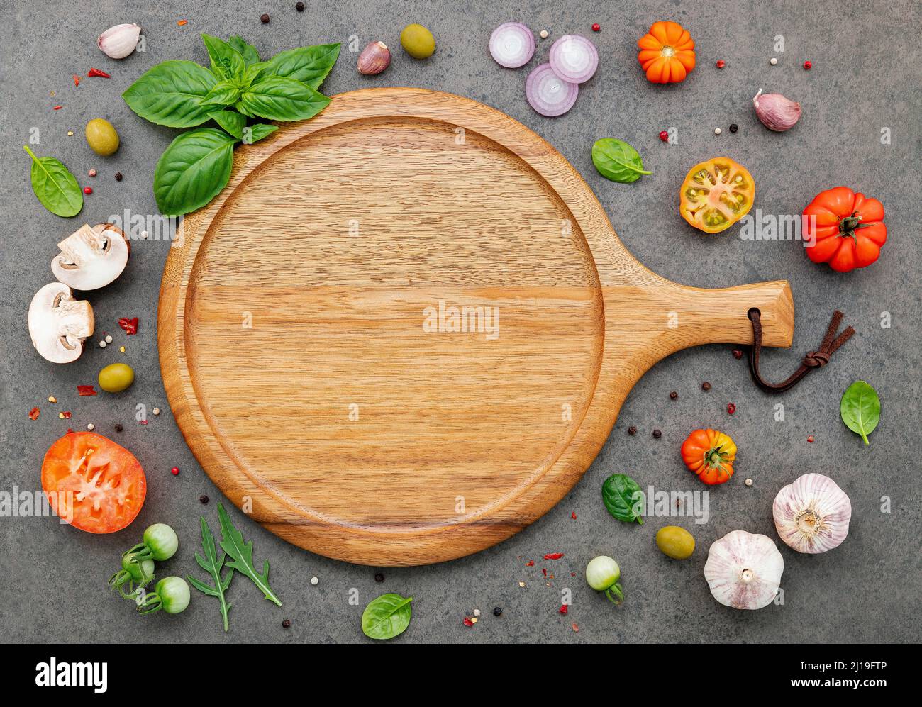 The ingredients for homemade pizza set up on dark stone background ...