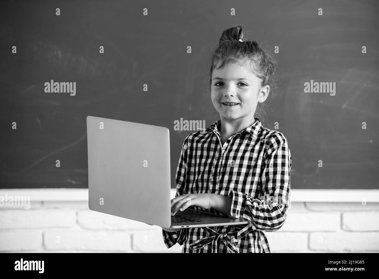 Cute little school kid girl study in a classroom. Online learning ...