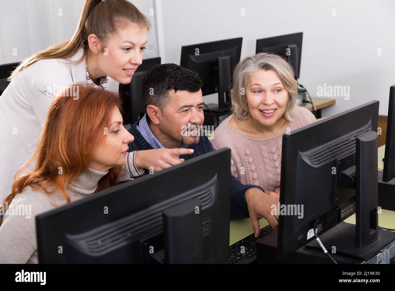 Business people grouped around laptop hi-res stock photography and ...