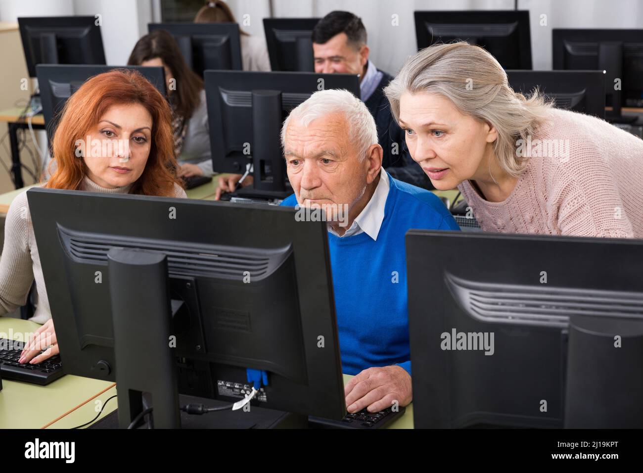 Students of different ages looking at monitor Stock Photo - Alamy