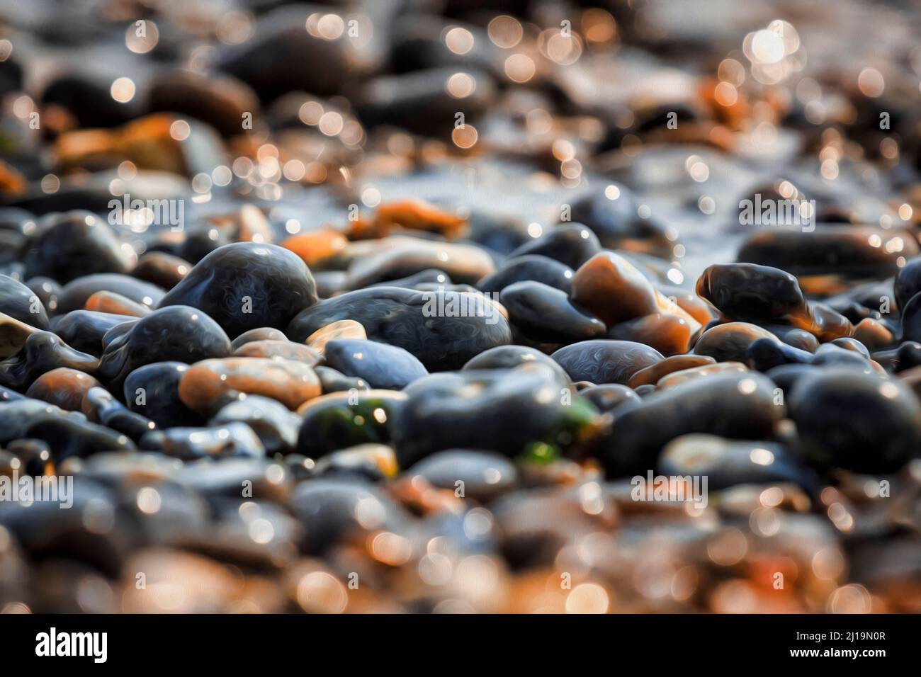 Shiny pebbles on the beach illuminated by the sun, twinkling lights ...