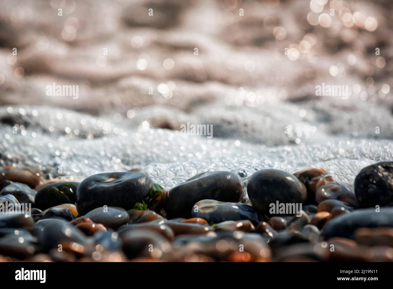 Shiny pebbles on the beach illuminated by the sun, twinkling lights ...